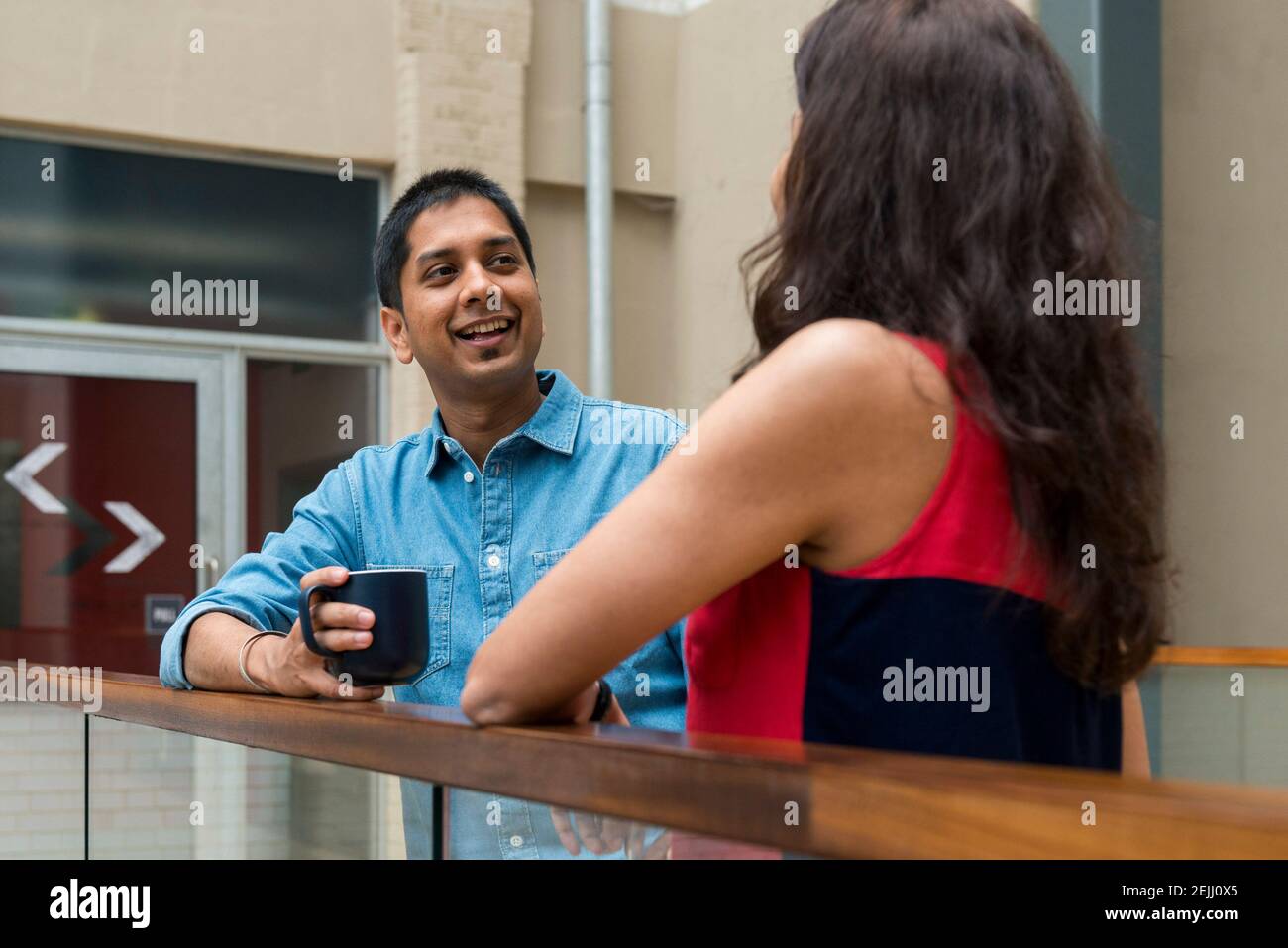 Two work colleagues chatting, listening and catching up in the communal ...