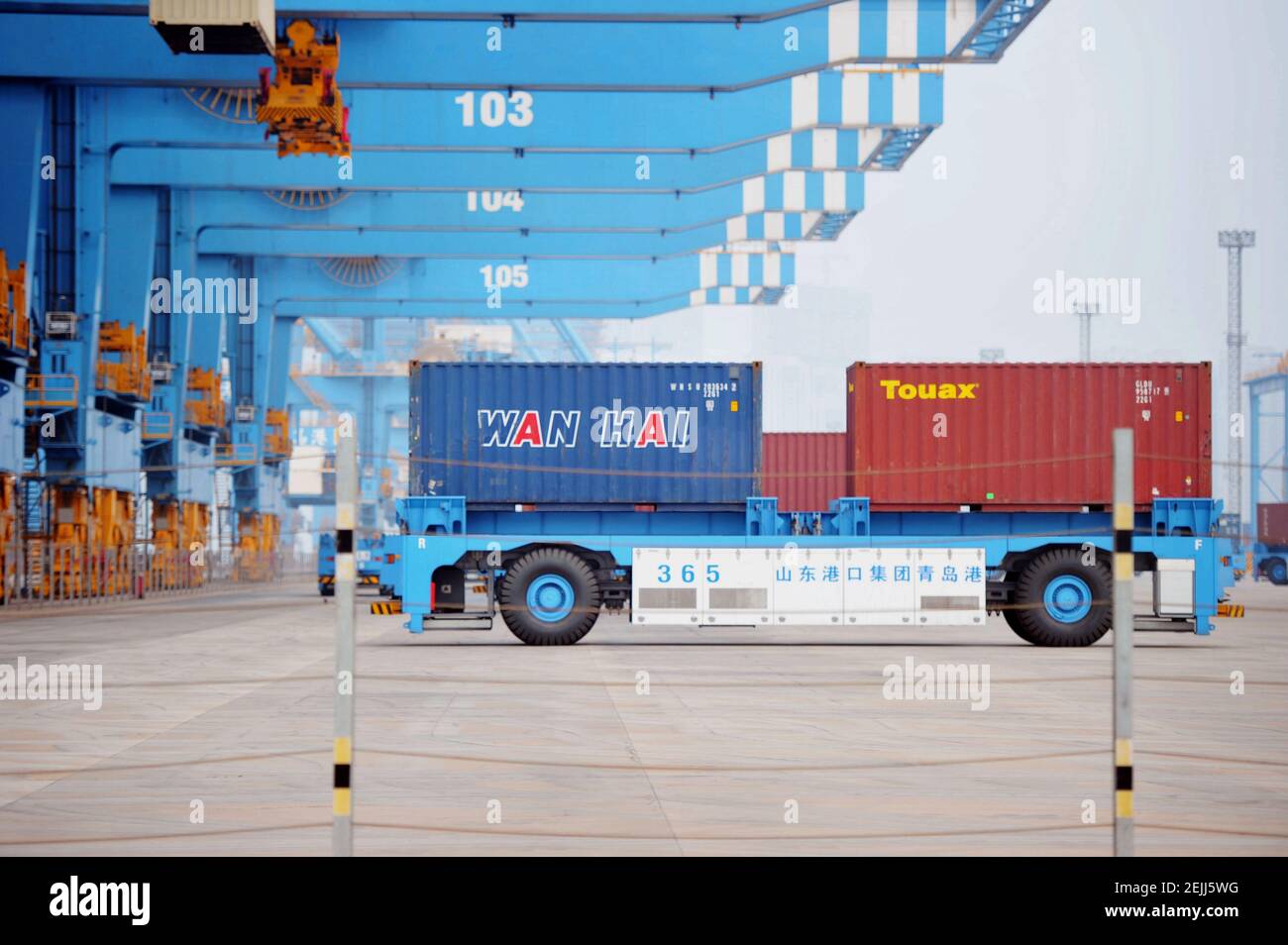Unmanned trucks transport containers unloaded from a ship on a quay at ...