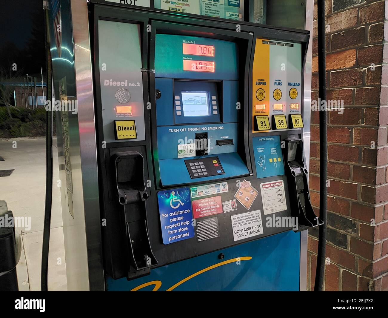 Digital readouts are visible on a gas pump at night at a gas station in ...