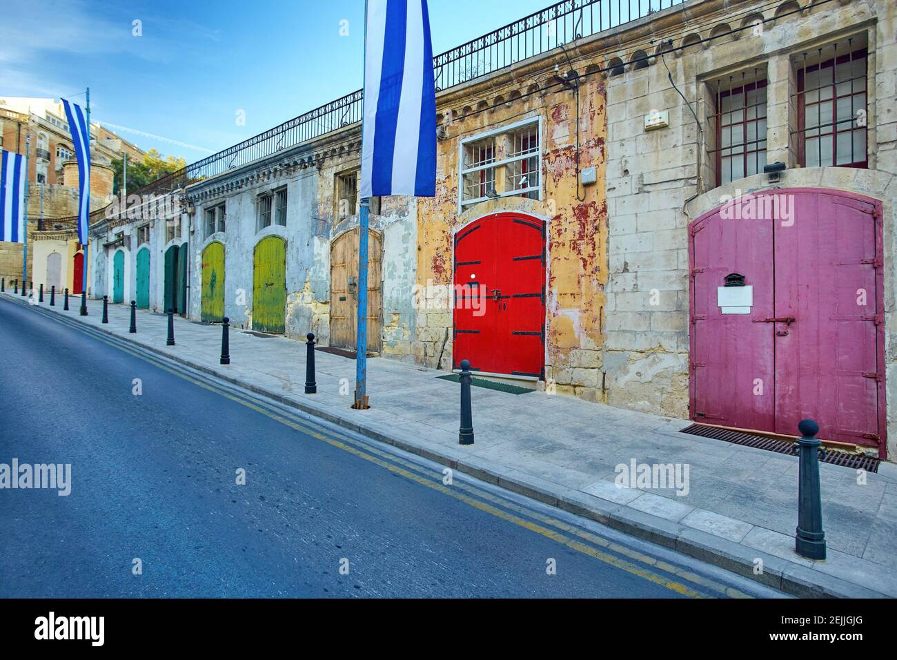 Ancient Valletta in evening colors. Multicolored gates in the street ...