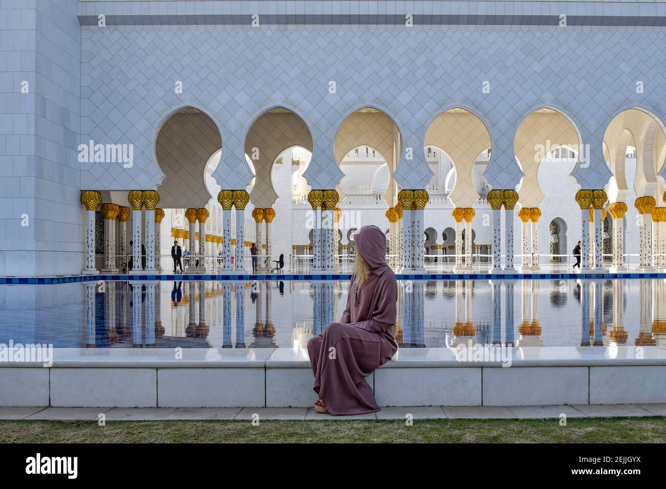 Female in a traditional abaya sitting near a pool in Sheikh Zayed Grand ...