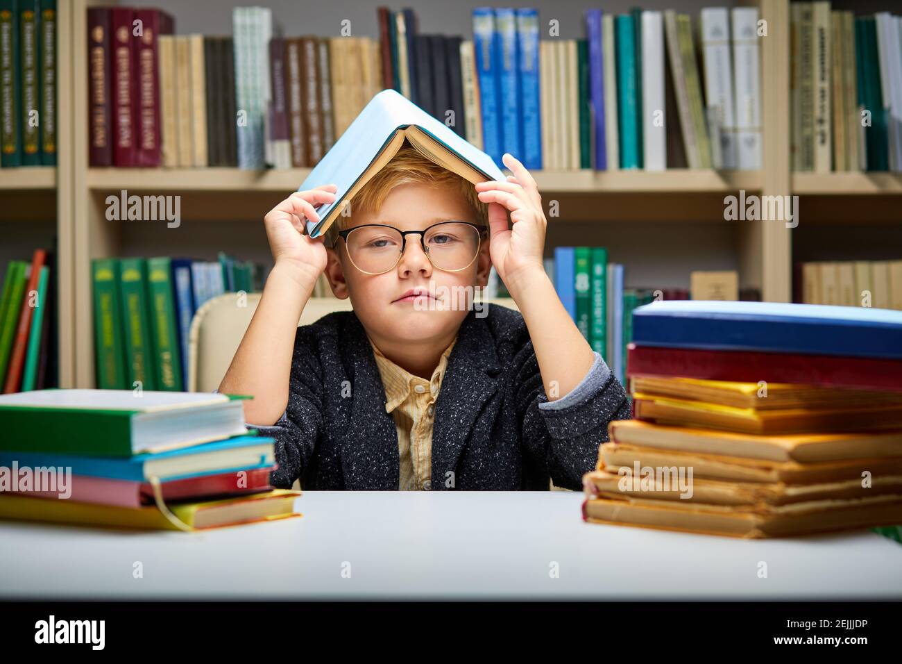 bored little boy tired of learning doing homework reading book ...