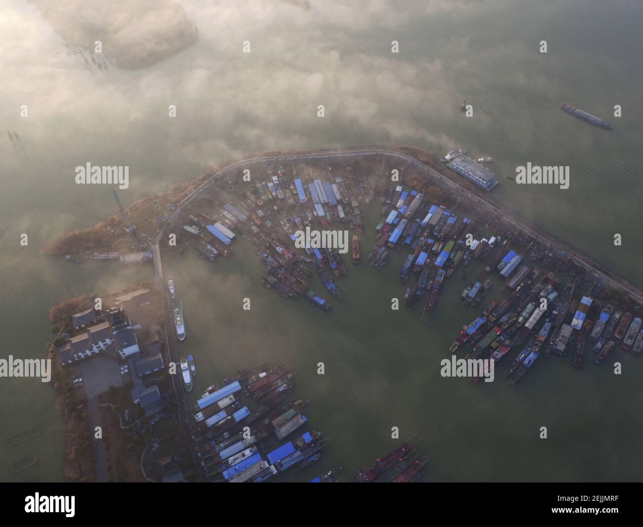 An aerial view of boats and vessels harboring at a pier and covered in ...