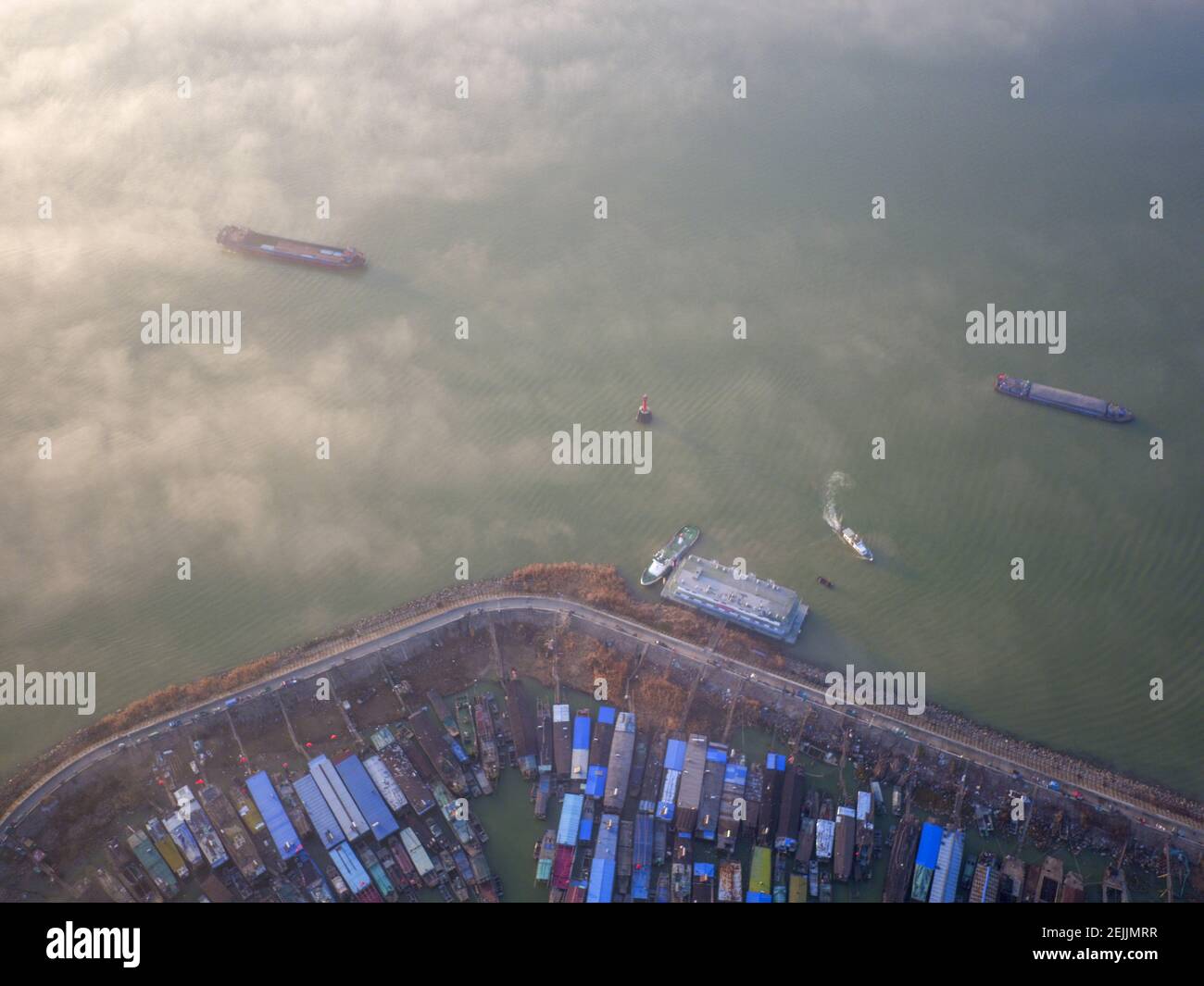 An aerial view of boats and vessels harboring at a pier and covered in ...