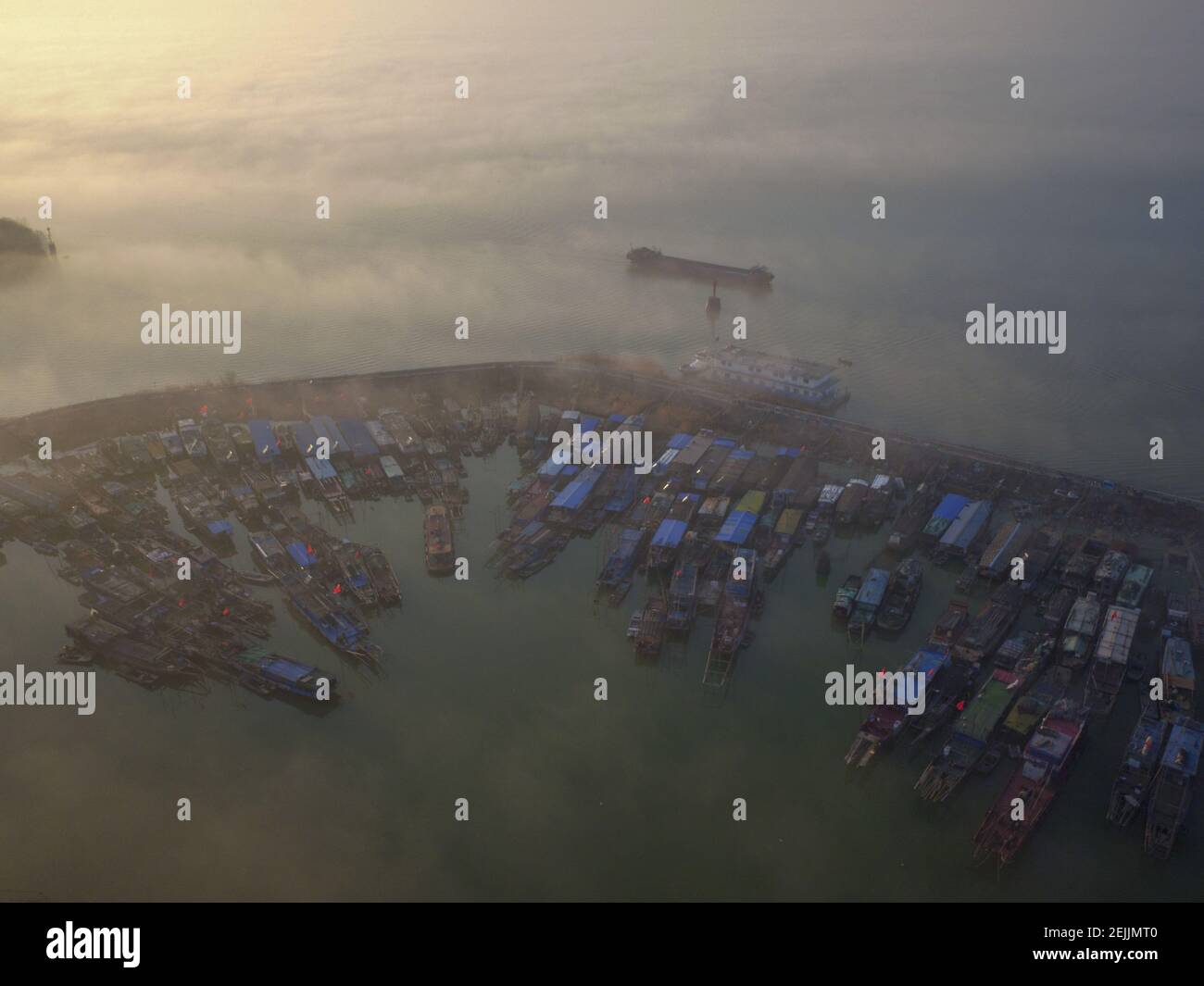 An aerial view of boats and vessels harboring at a pier and covered in ...
