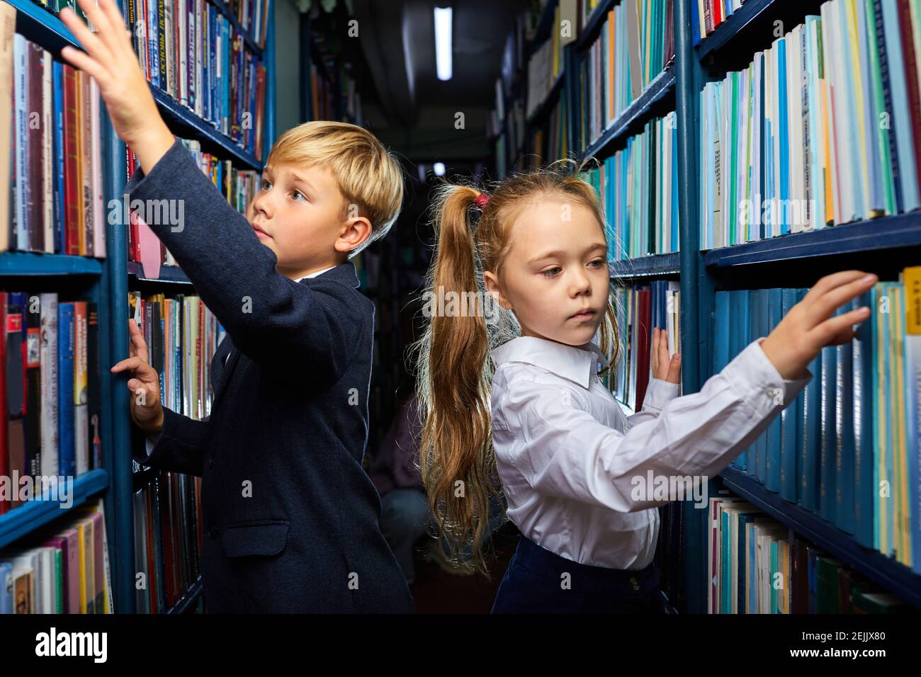 kids boy and girl choose books in library for school, going to read ...