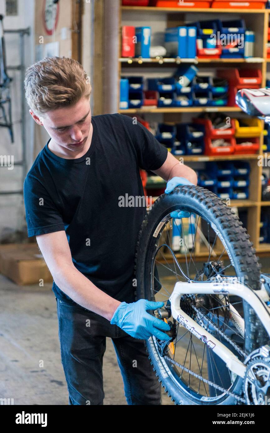 A bike mechanic works on the wheels of a bike servicing them Stock ...