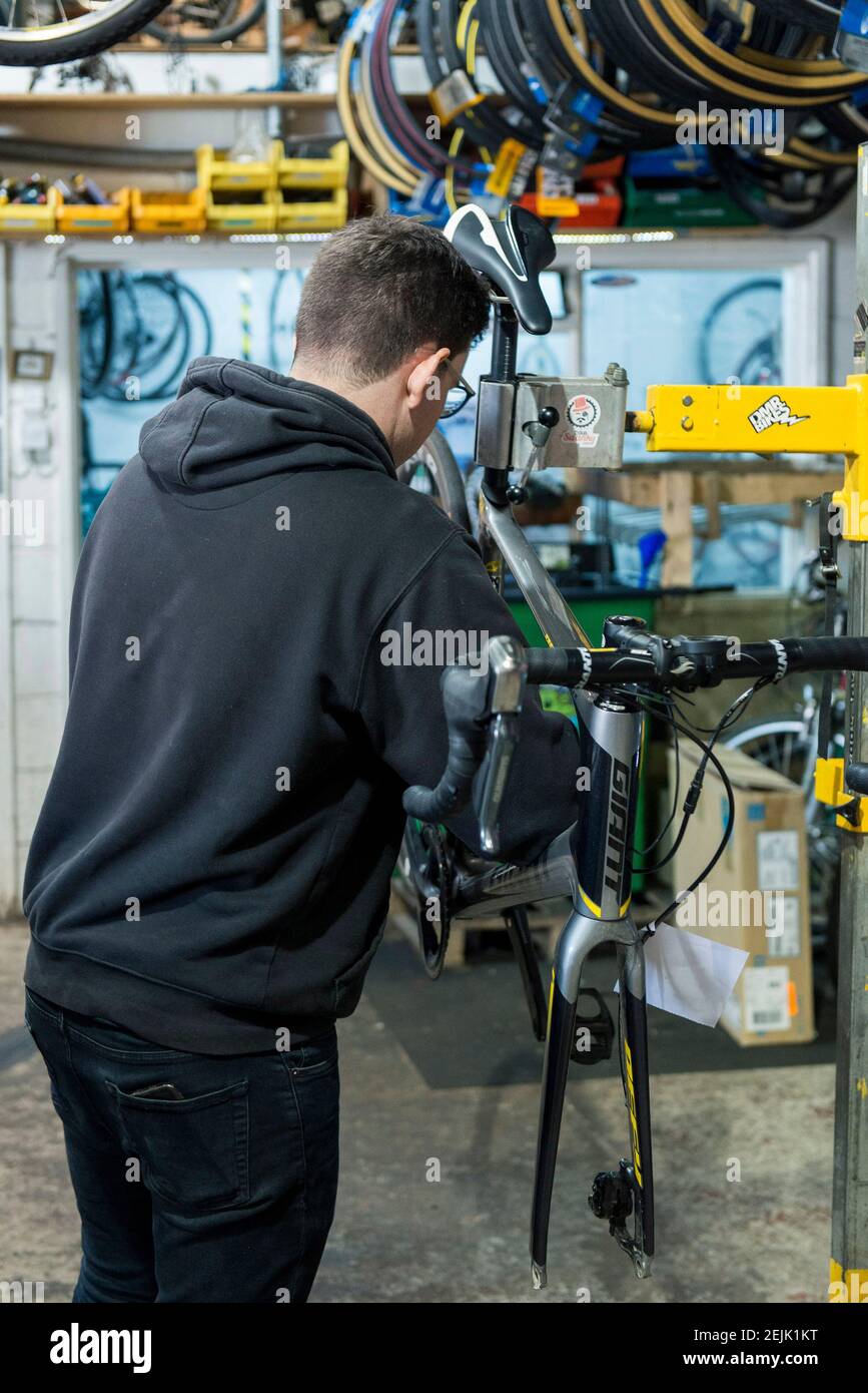 A bike mechanic works on fixing a bike in a cycle industry business Stock Photo - Alamy