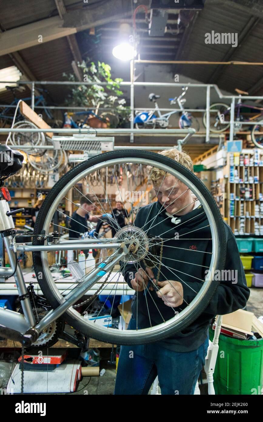 A bike mechanic works on the wheels of a bike servicing them Stock ...