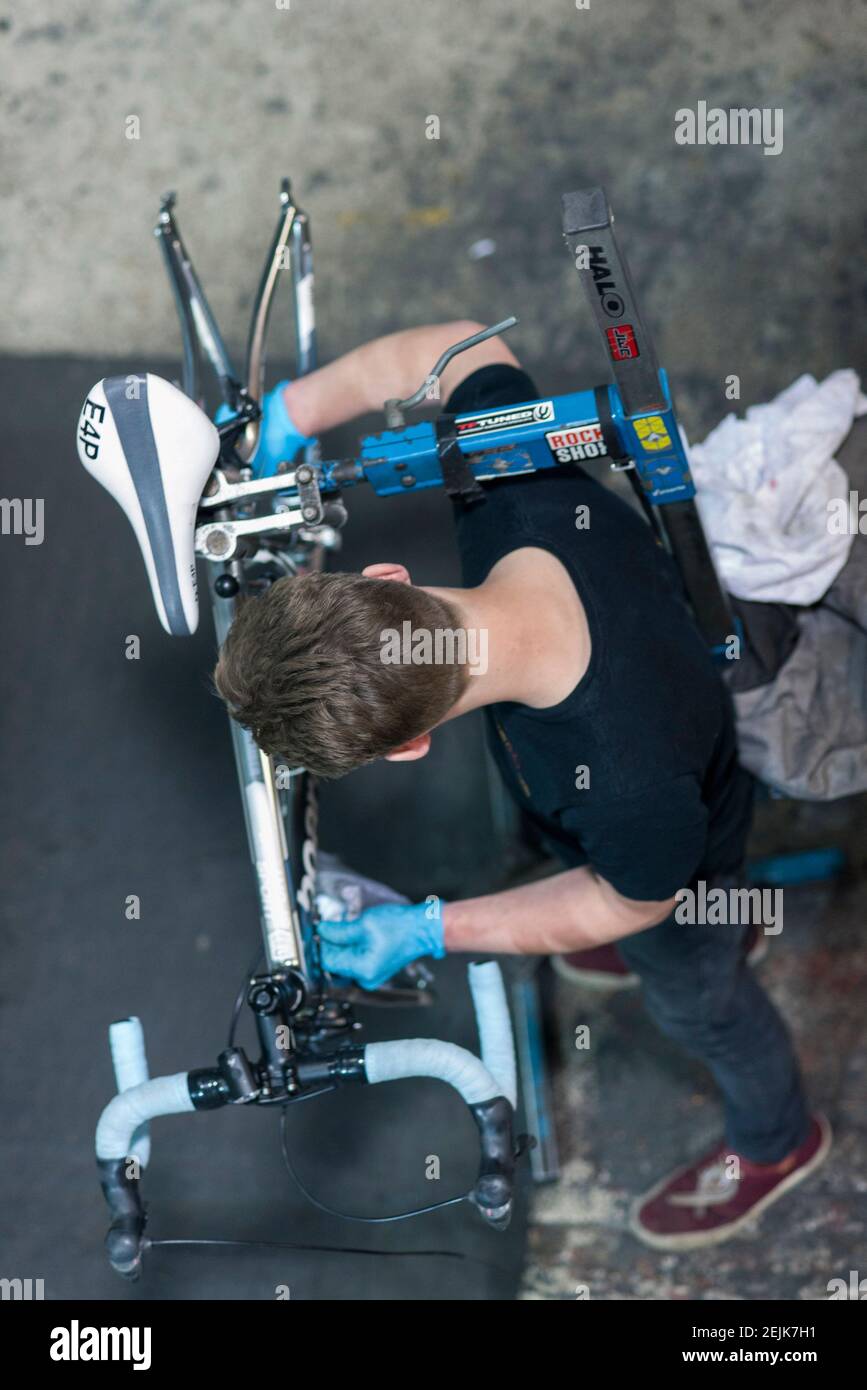 A bike mechanic works on fixing a bike in a cycle industry business ...