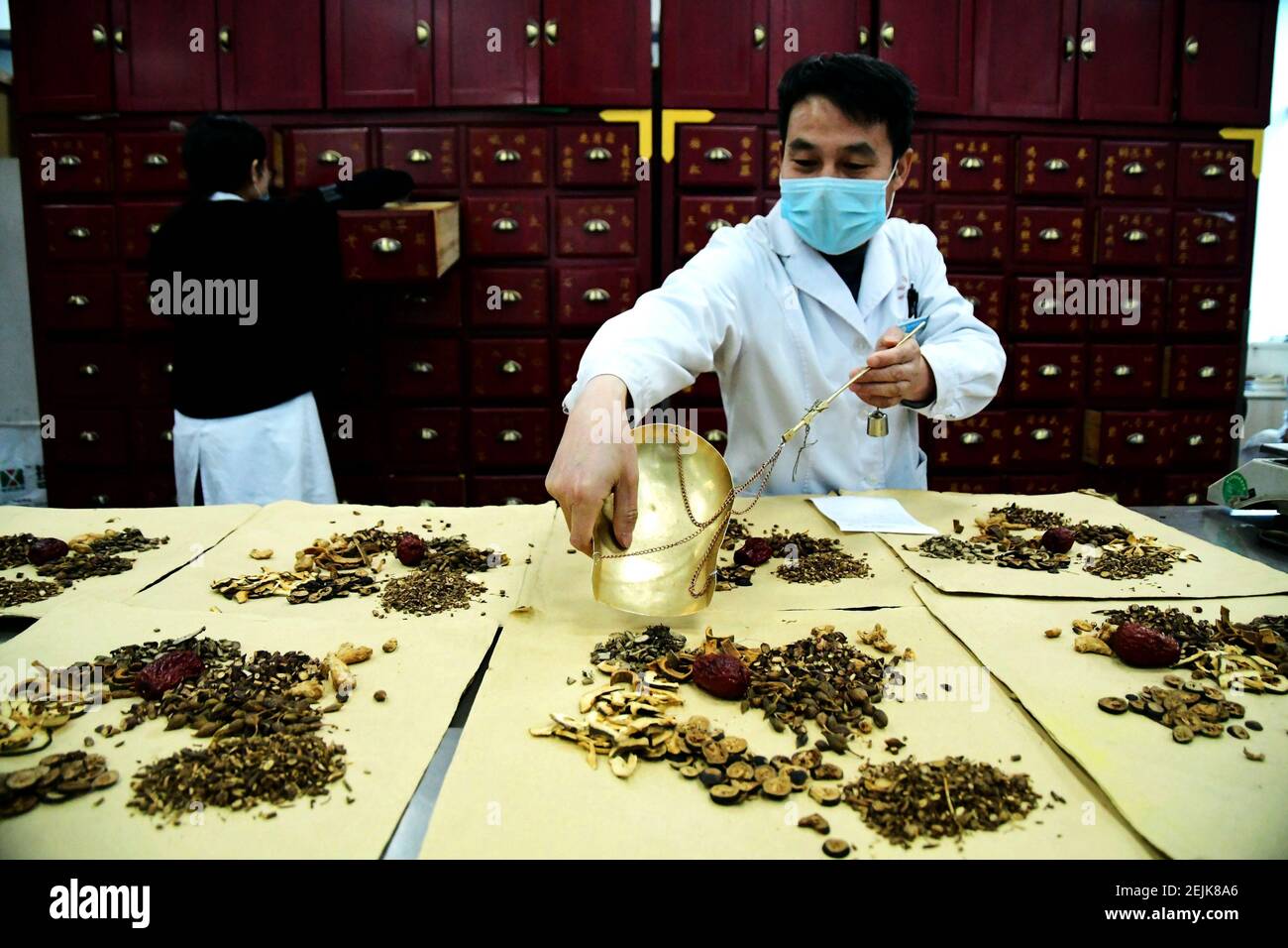 A Chinese medicine man is filling a medicine for a patient. (Photo by ...