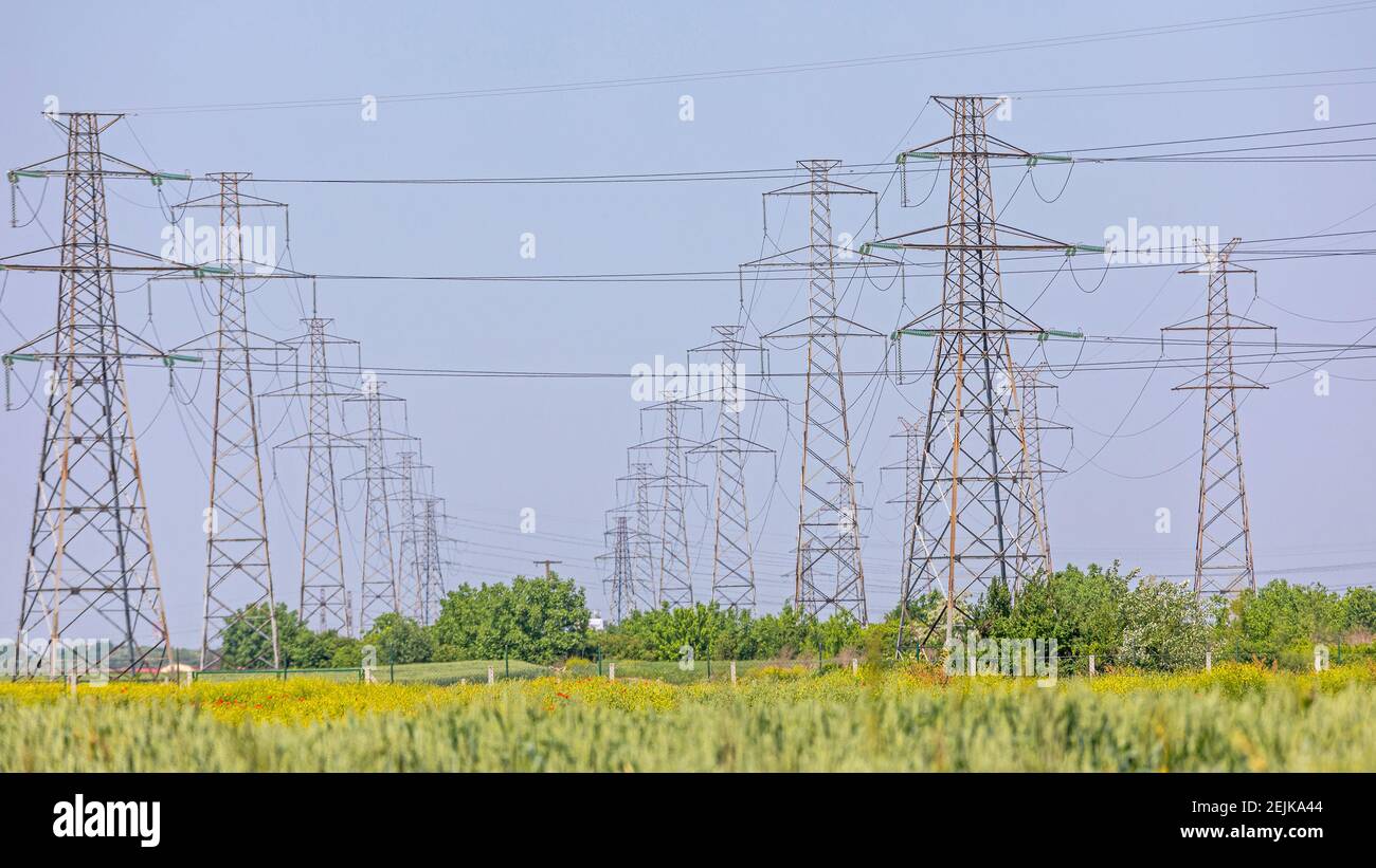 High Voltage Power Lines Grid Transmission Towers in Field Stock Photo ...