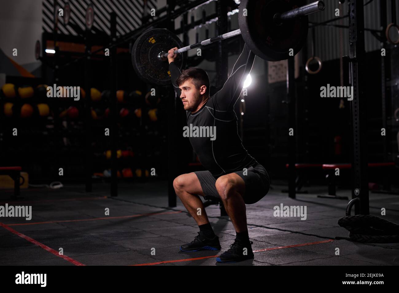 Fitness man doing aweight training by lifting barbell. Young athlete ...
