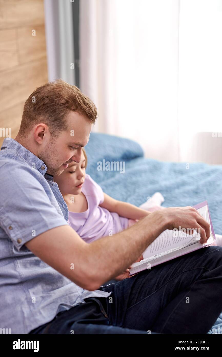 father and daughter spend time reading book at weekends, lovely child ...