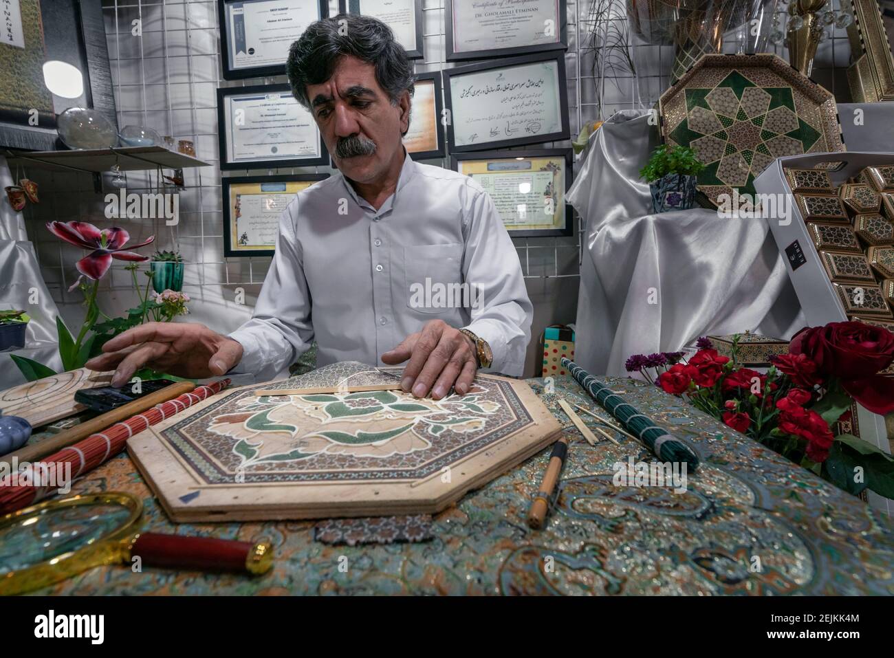 Shiraz, Iran - 04.10.2019: Iranian Khatam master woking behind the desk ...