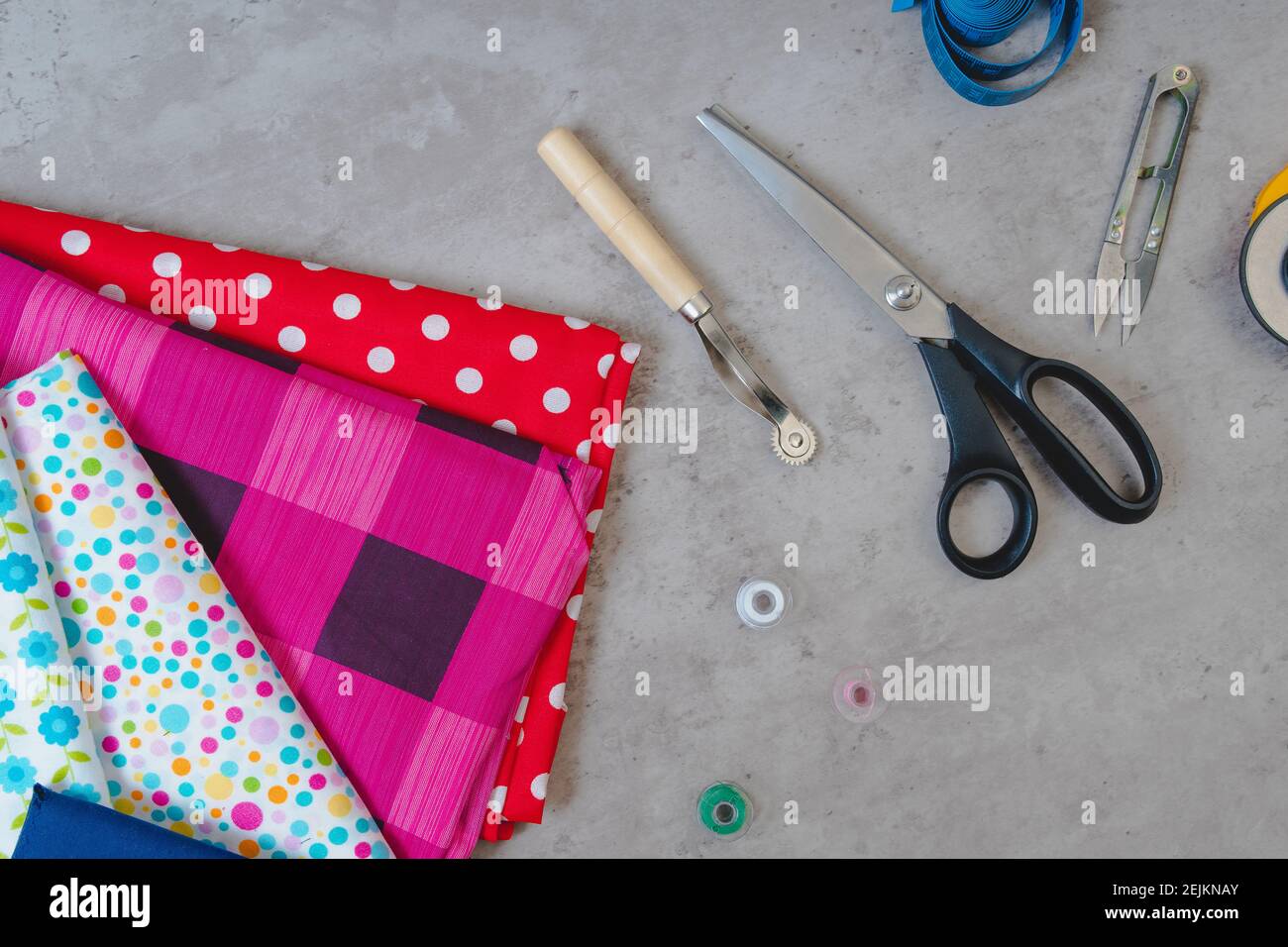 Cloth, buttons, zipper, tape measure, tools of a tailor on a table ...