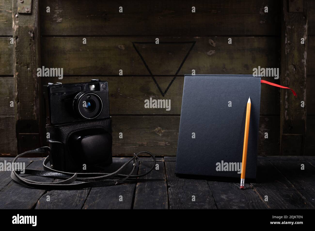 Old film camera and notepad for writing. Black camera and black notepad ...