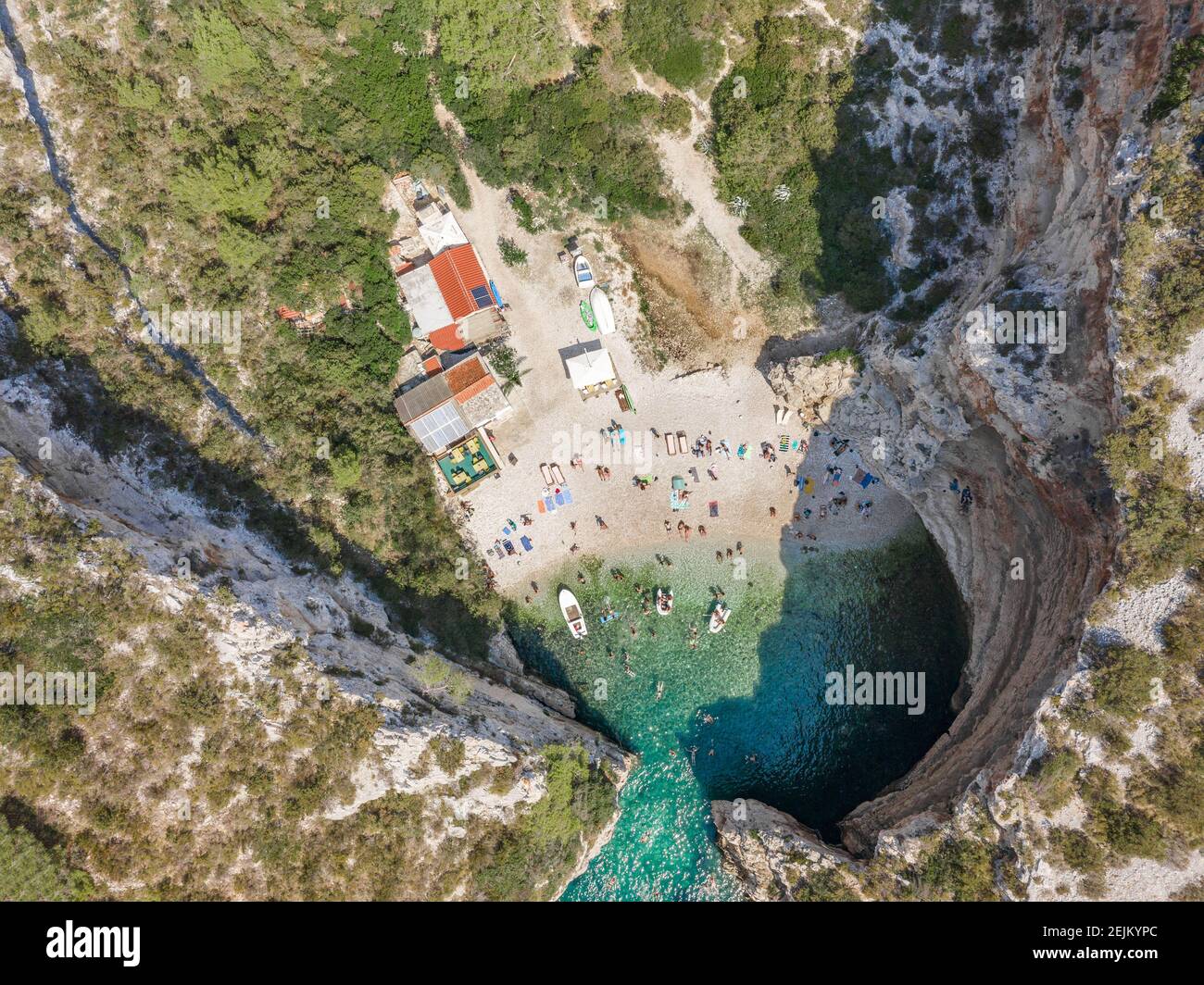 Aerial overhead drone shot of tourists swim sunbath at Stiniva beach on ...