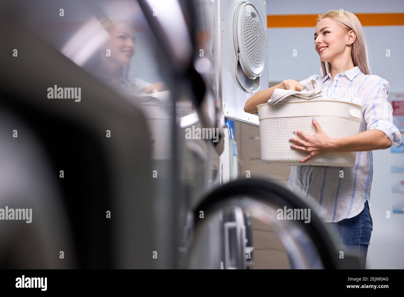 Woman getting towels form washing machine, feeling softness of linen ...
