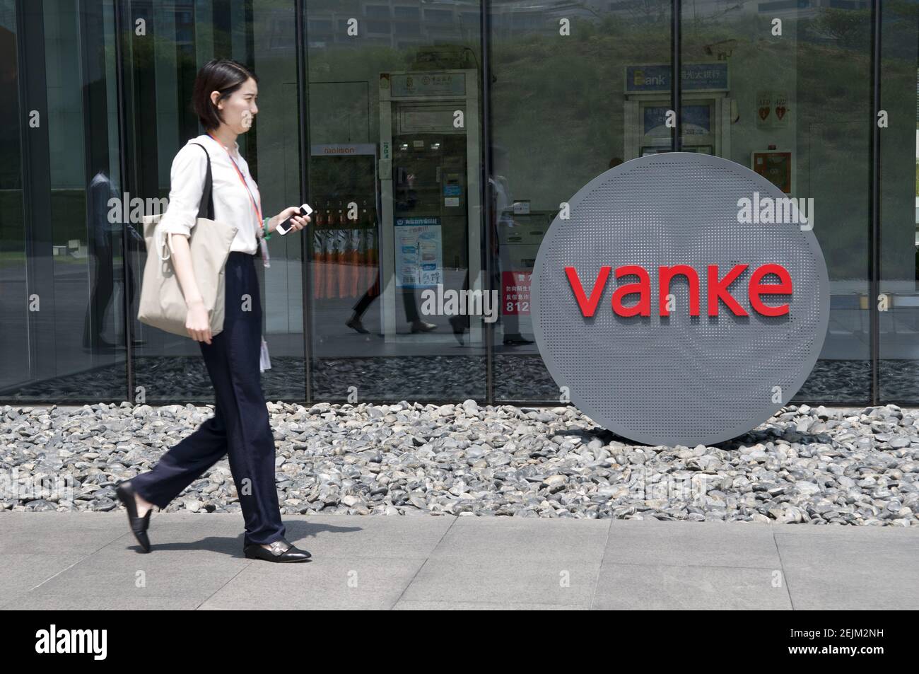 In this unlocated and undated photo, pedestrians walk past the logo of ...