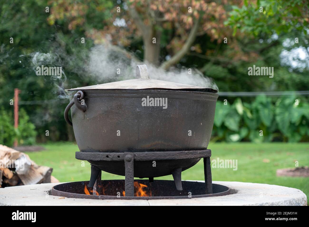 Closeup shot of an old metal pot with steam on the fire Stock Photo - Alamy