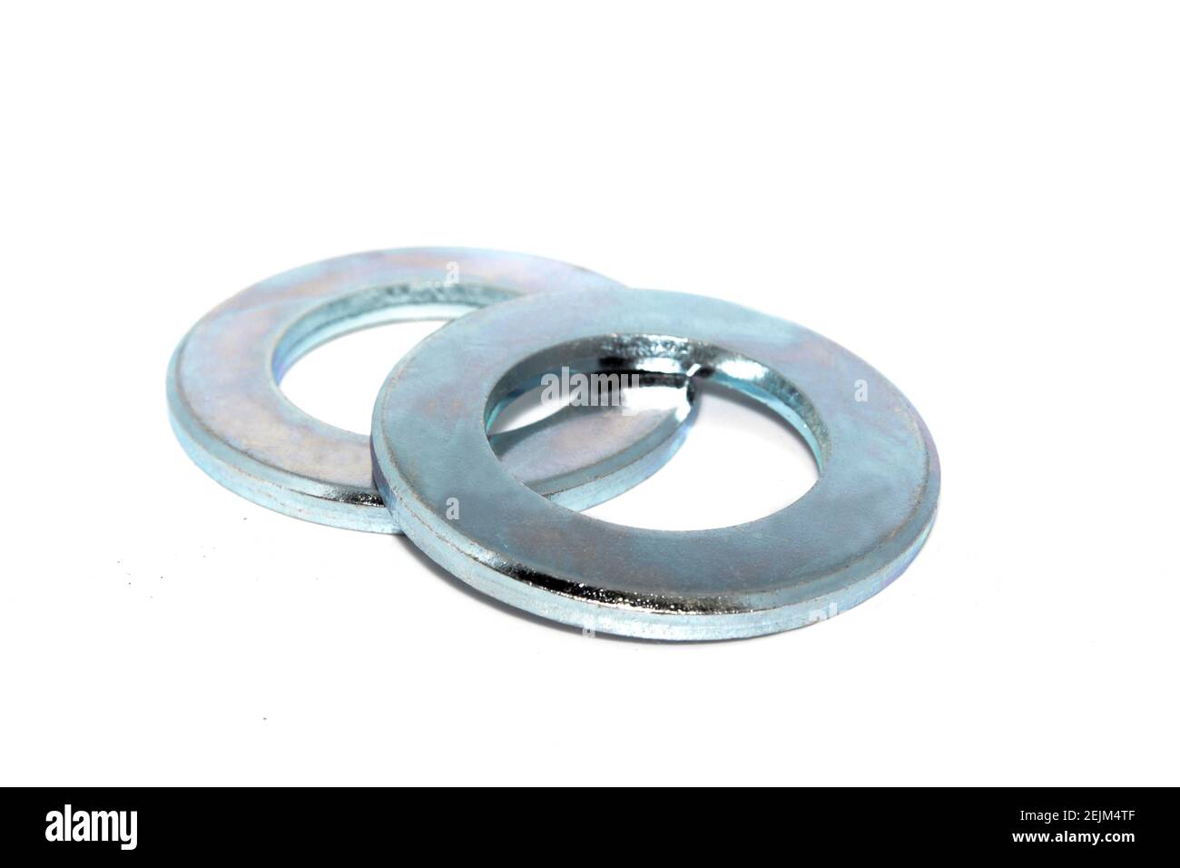 A couple of big industrial galvanized steel washers on white background ...