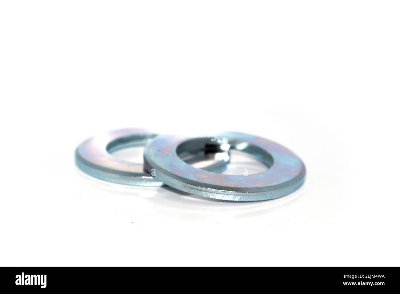 A couple of big industrial galvanized steel washers on white background ...