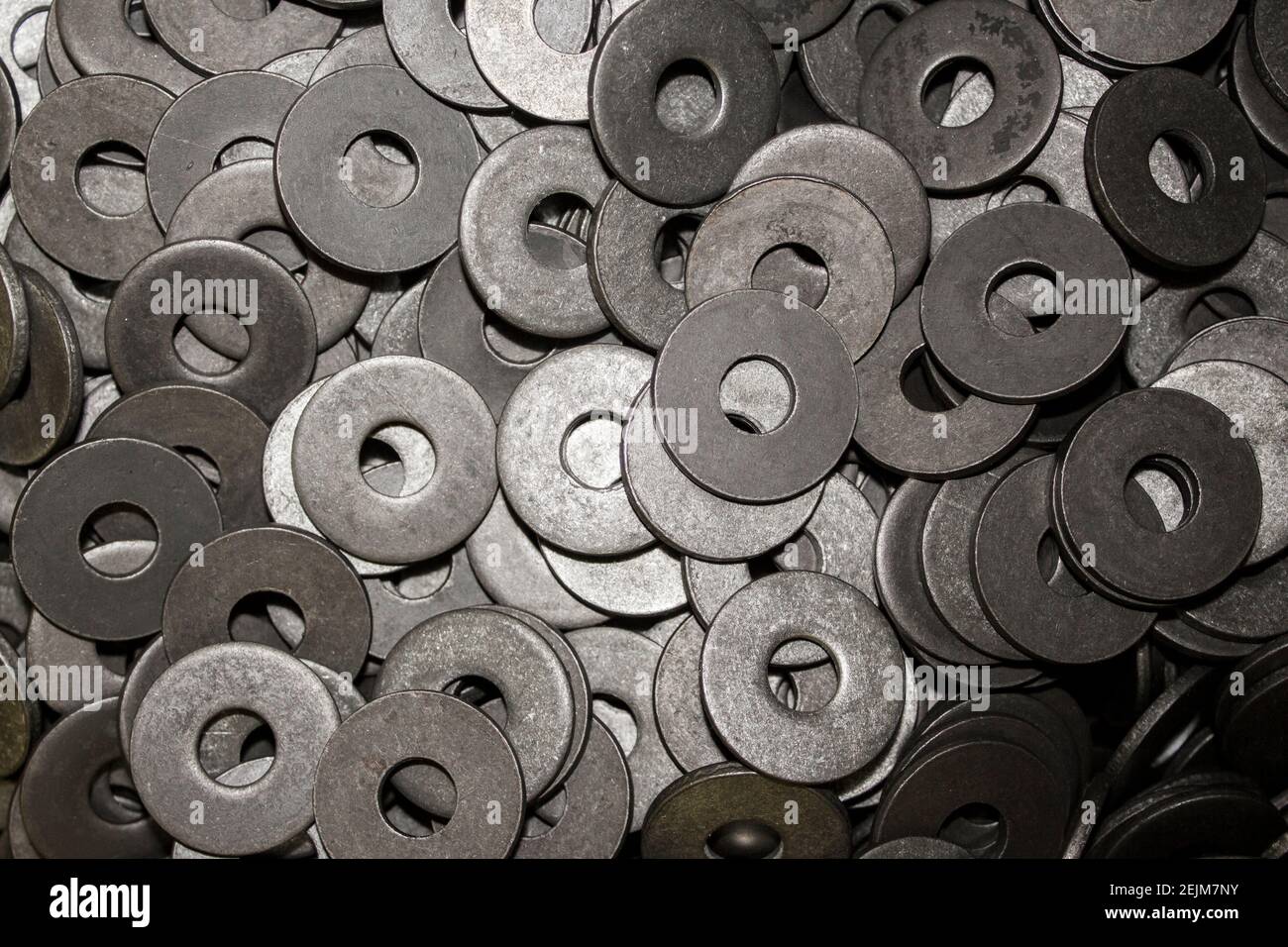 Lots of big industrial steel washers on a pile Stock Photo - Alamy