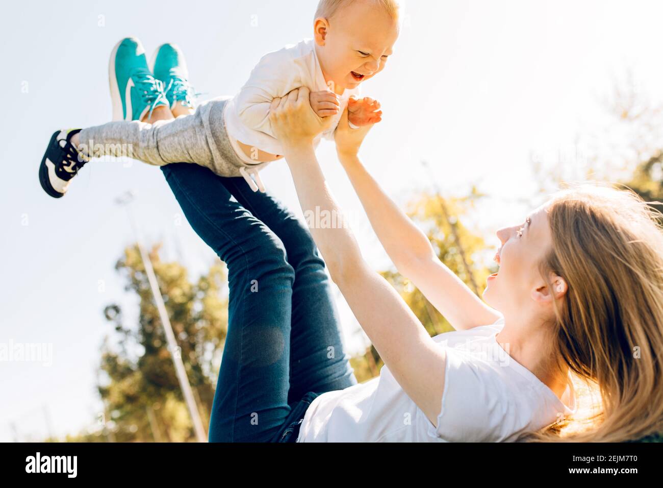 mom playing and throwing up happy little son while having fun together ...