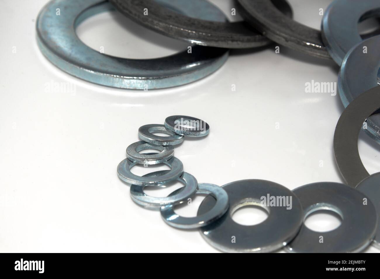 Variety of industrial galvanized steel washers on white background ...