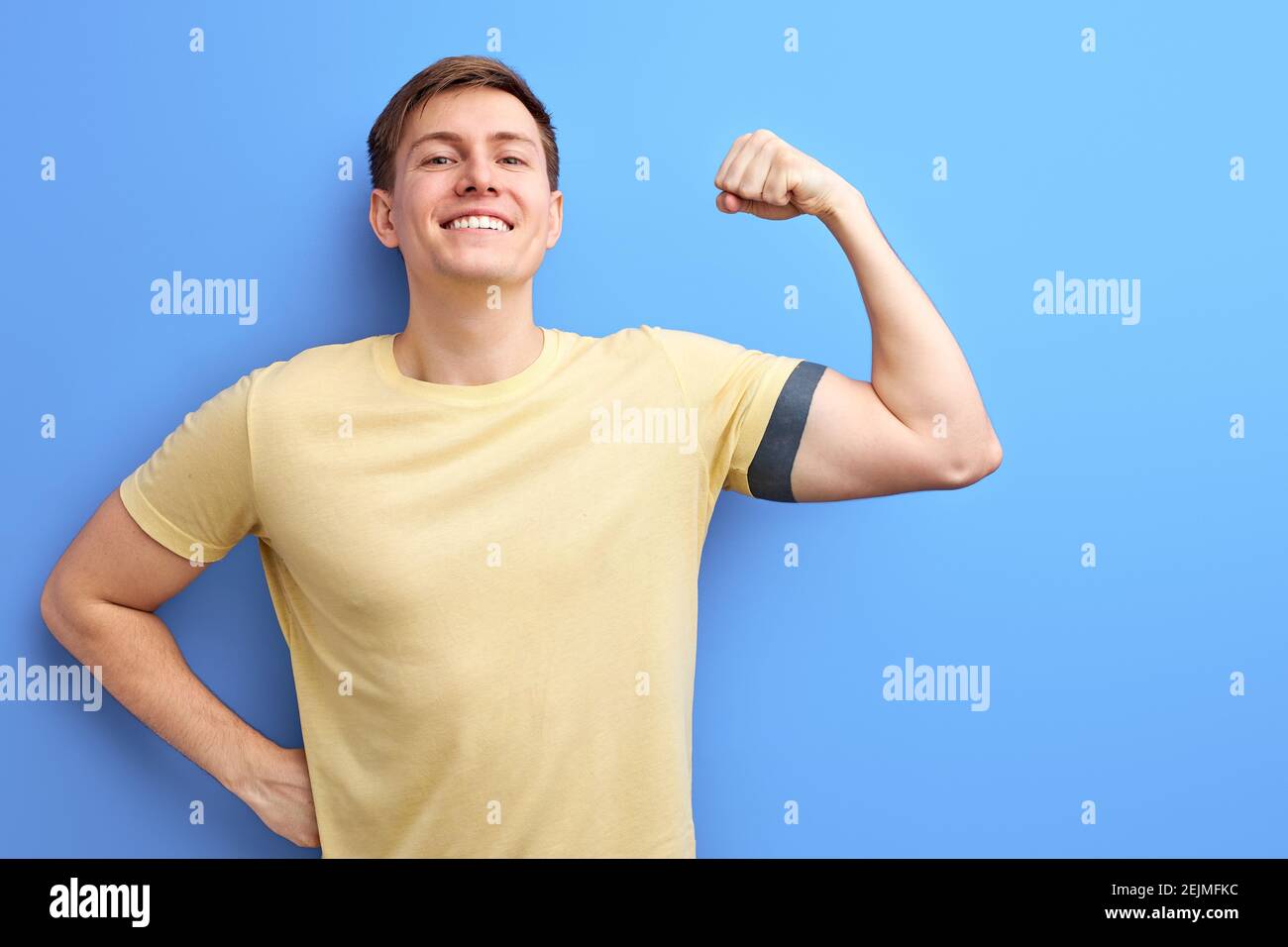 athlete guy showing arm muscles, his strength, male in casual t-shirt ...