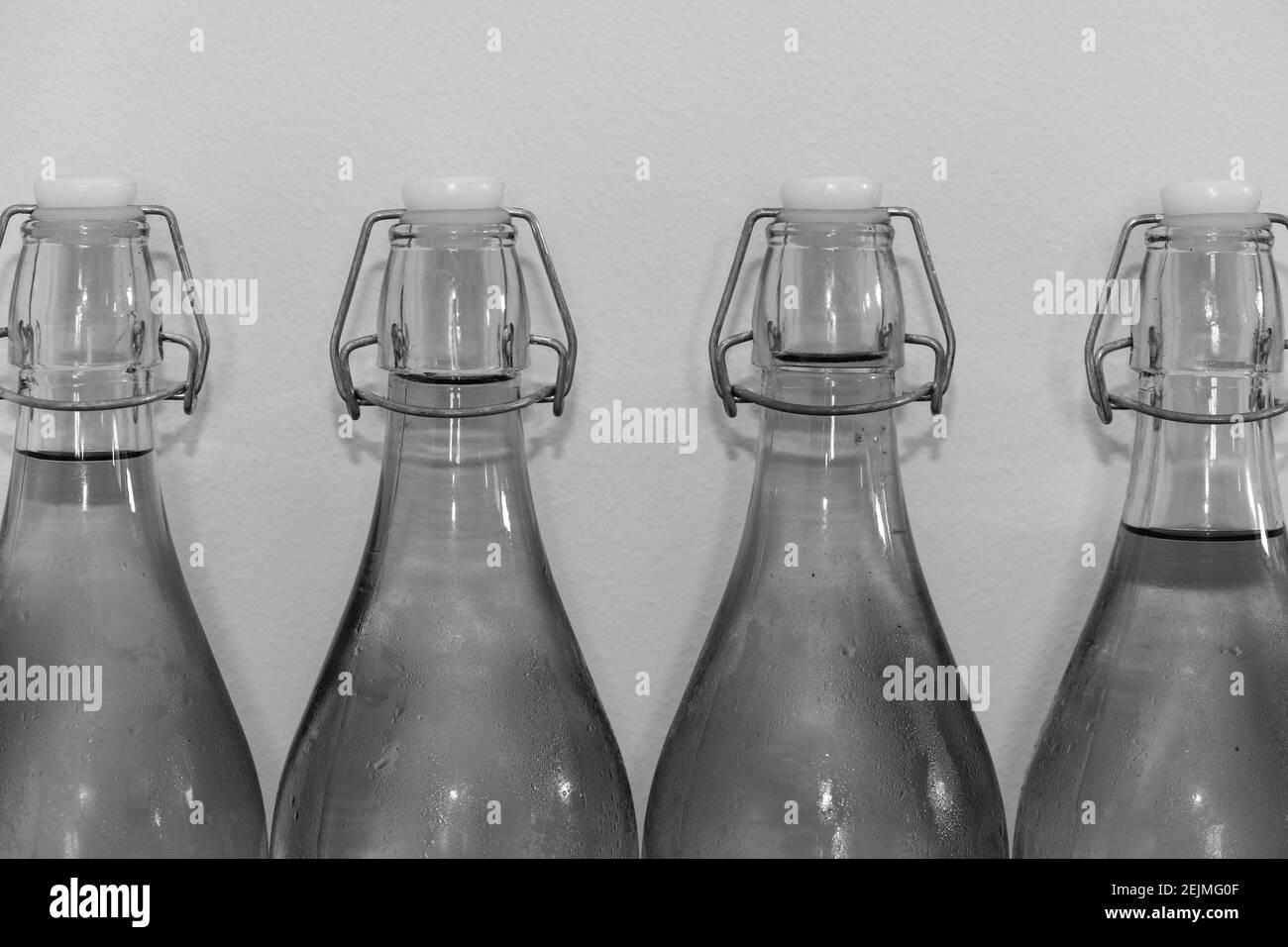 Black and white photo of a row of flip top bottles of home made cider ...