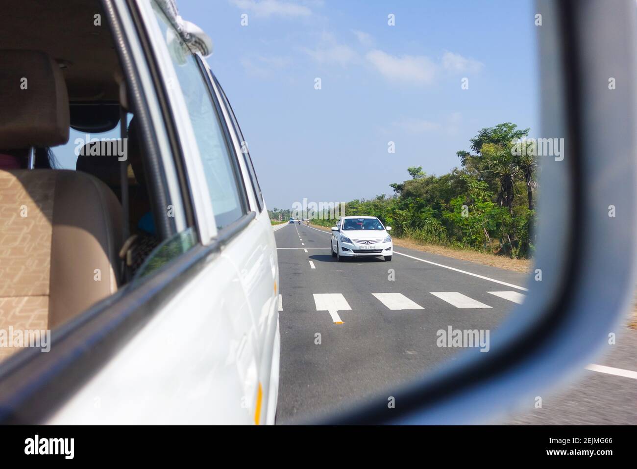 View of car and road from a side view mirror driving in East Coast Road ...