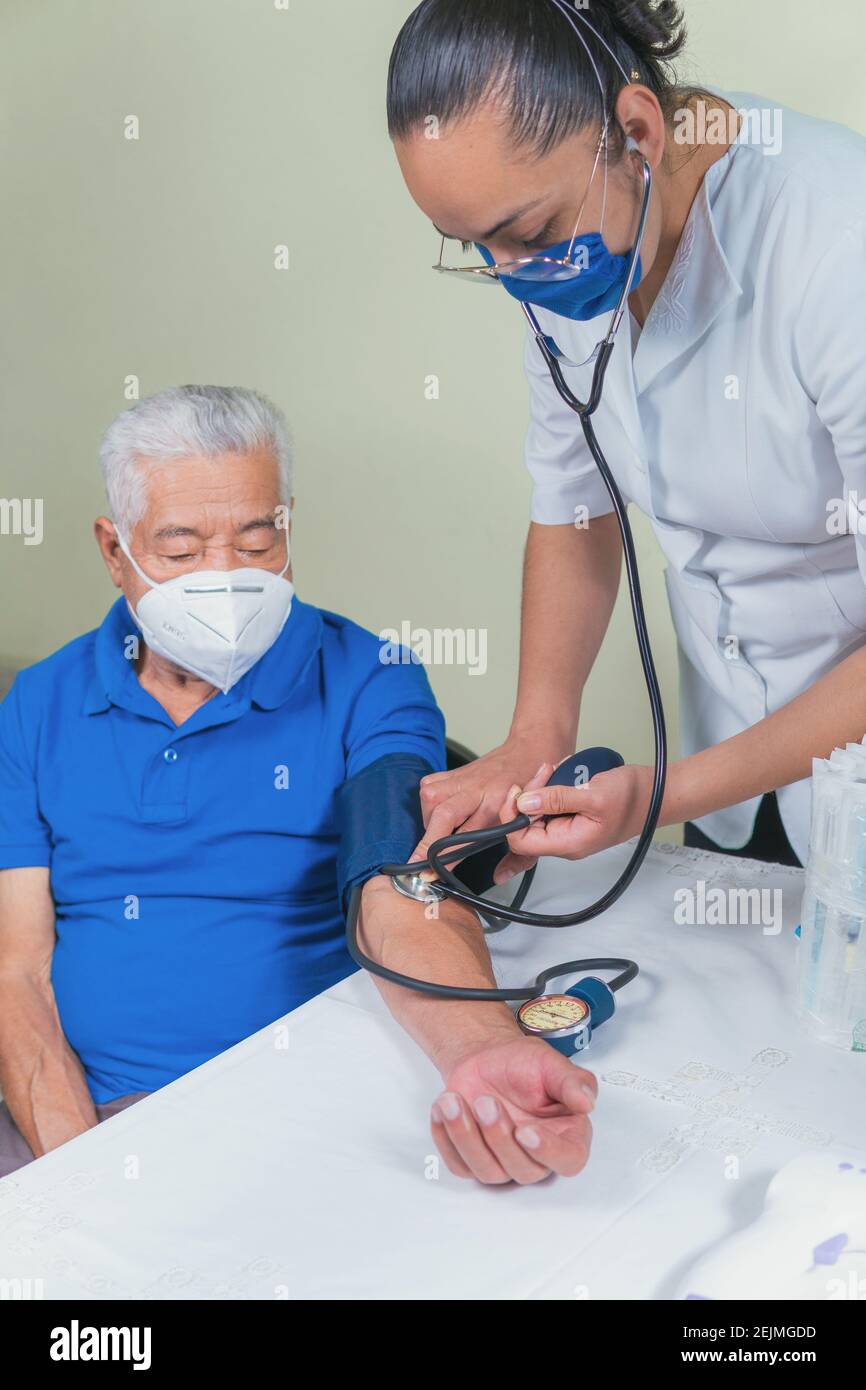 shows how to measure blood pressure in an older man Stock Photo - Alamy