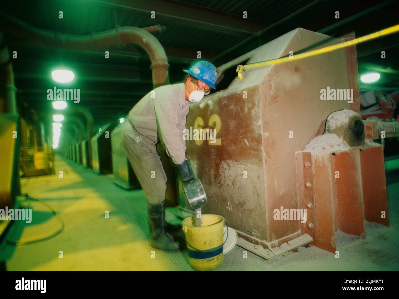 An open pit copper mine worker tests copper content in crushed rock ...