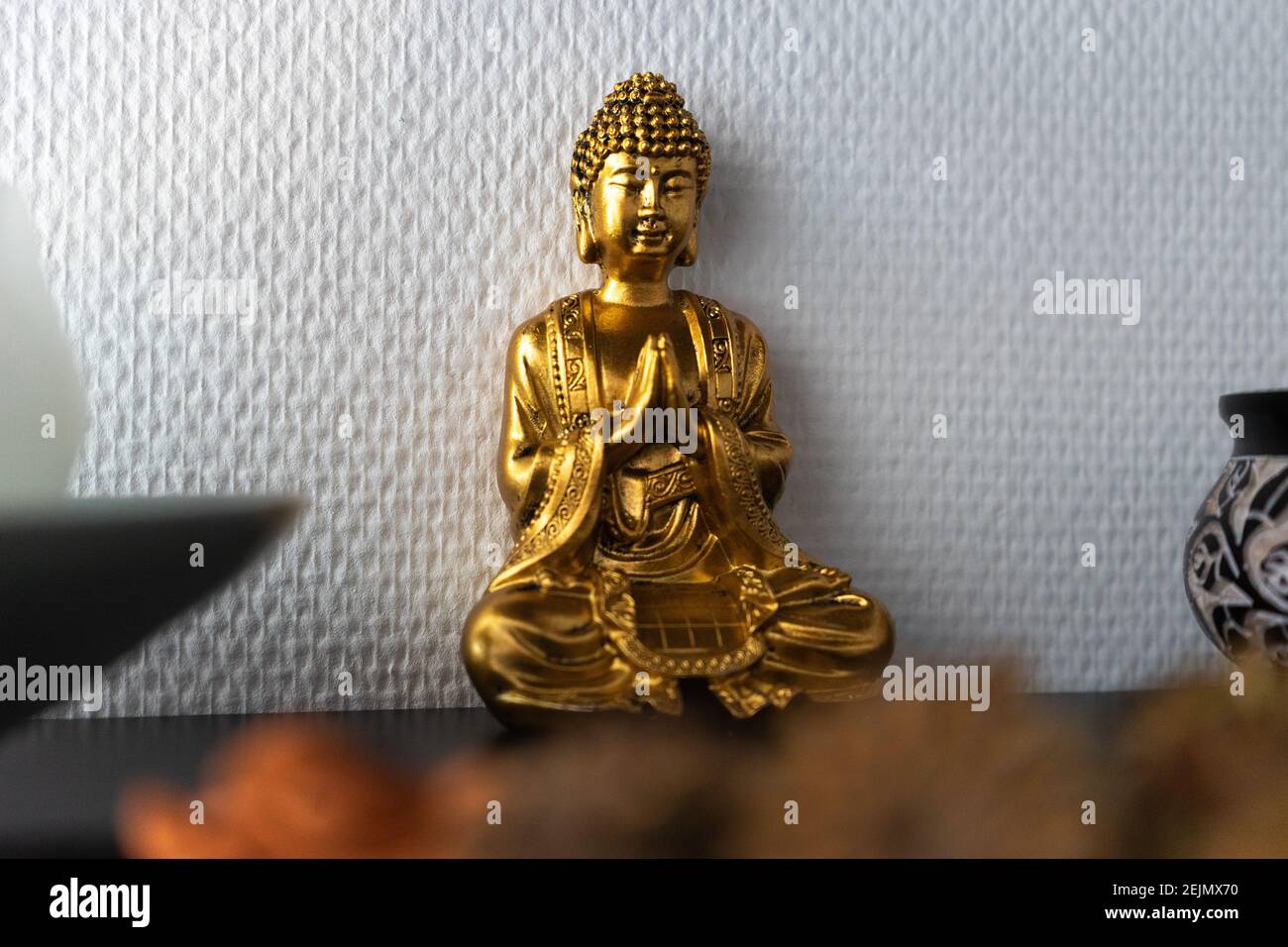 Golden Buddha statue inside house in front of a white wall Stock Photo ...