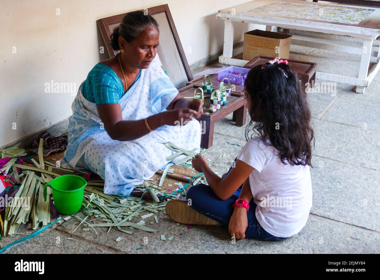 Woman teaching a child to make palm leaf based materials Stock Photo ...