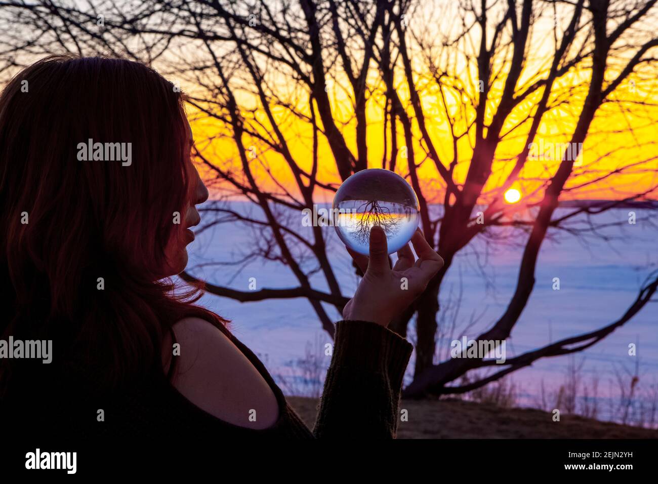 Esoteric Girl looking into the future in a Crystal Ball during a golden ...