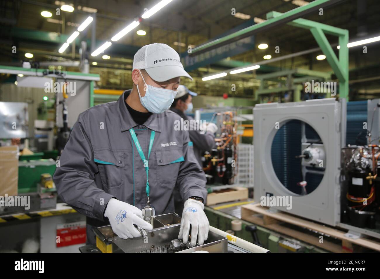 Chinese workers assemble air conditioners on the production line at a ...