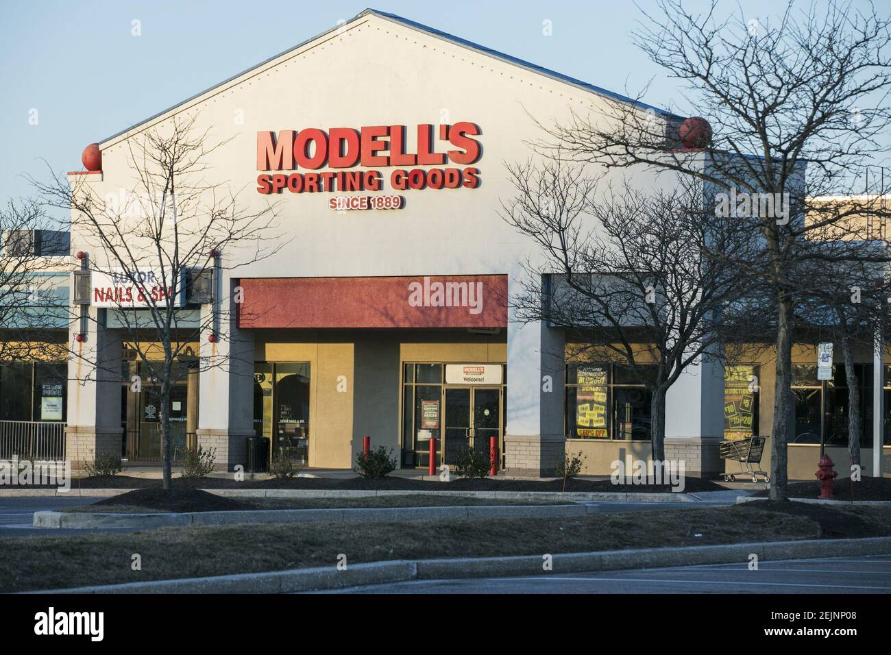 A logo sign outside of a Modell's Sporting Goods retail store location ...