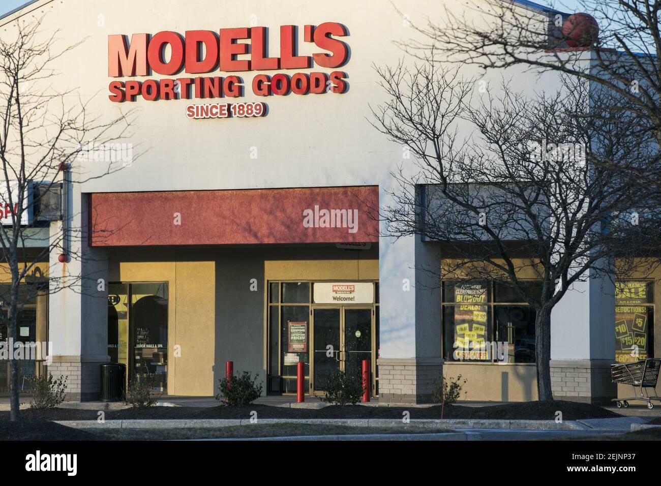 A logo sign outside of a Modell's Sporting Goods retail store location ...