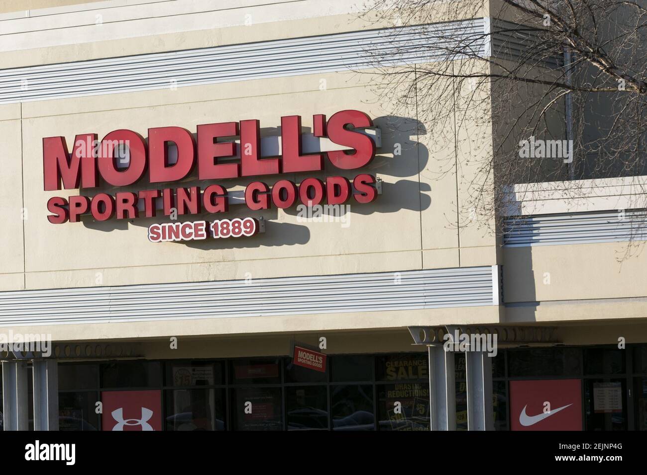 A logo sign outside of a Modell's Sporting Goods retail store location ...