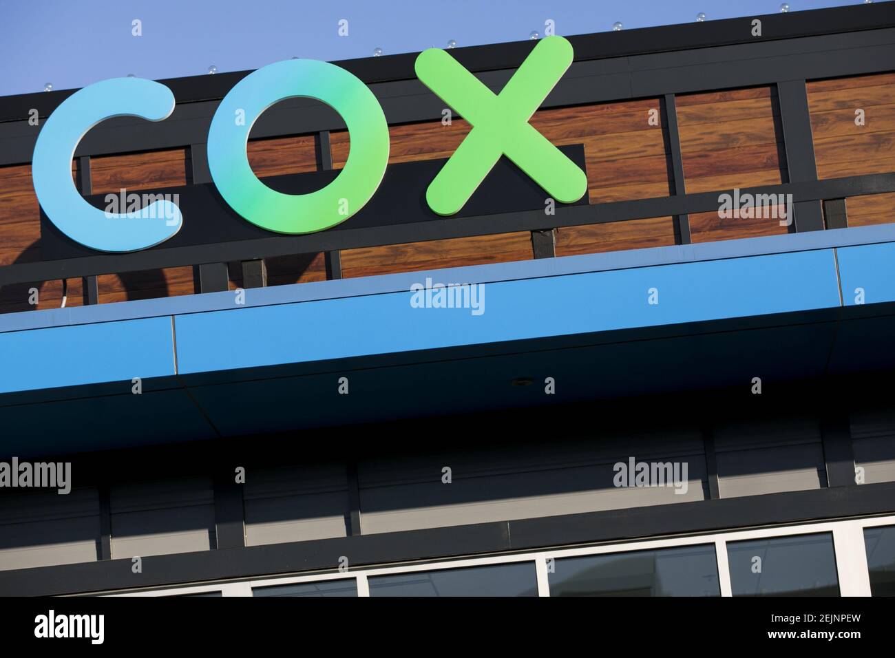 A logo sign outside of a Cox Communications retail store location in ...