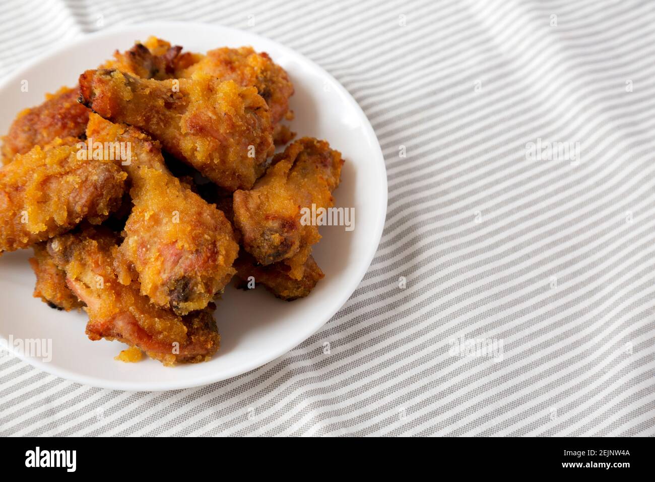 Homemade Spicy Mango Chicken Wings on a white plate on cloth, side view ...