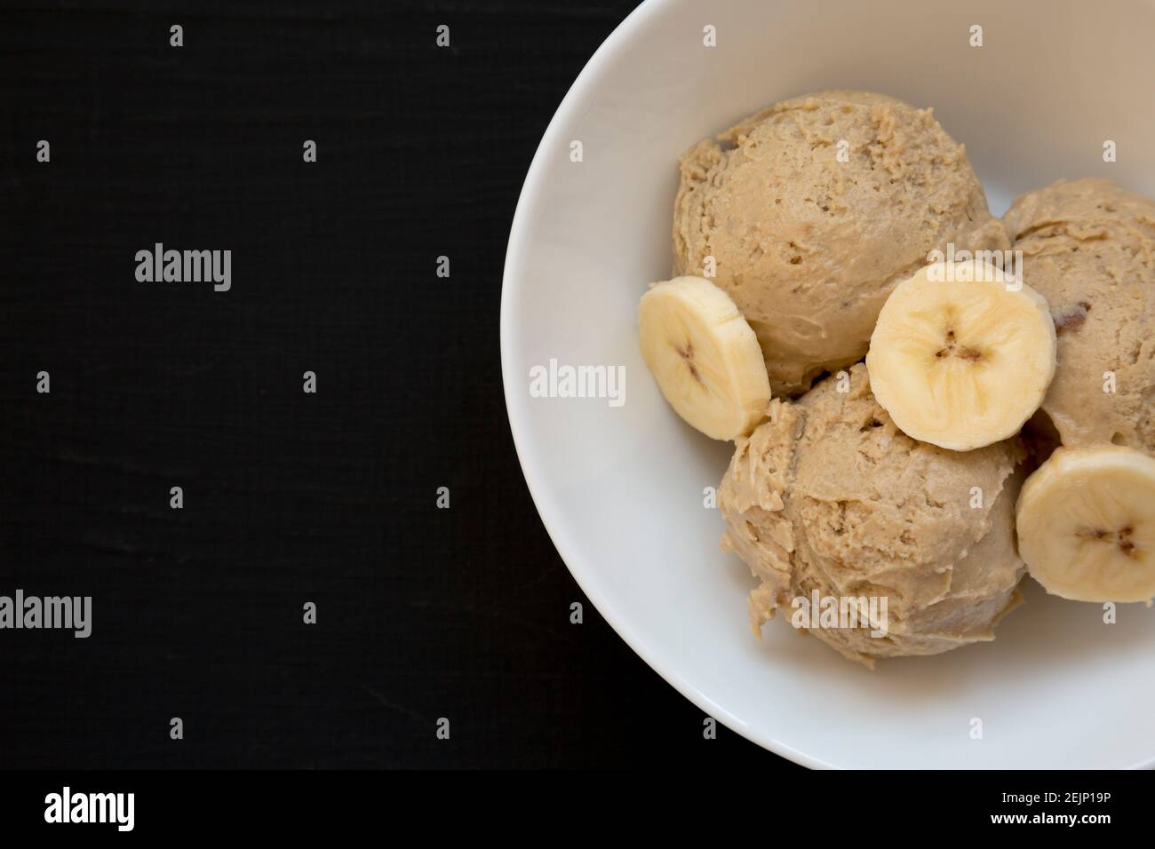 Homemade Peanut Butter Banana Ice Cream in a Bowl on a black background ...