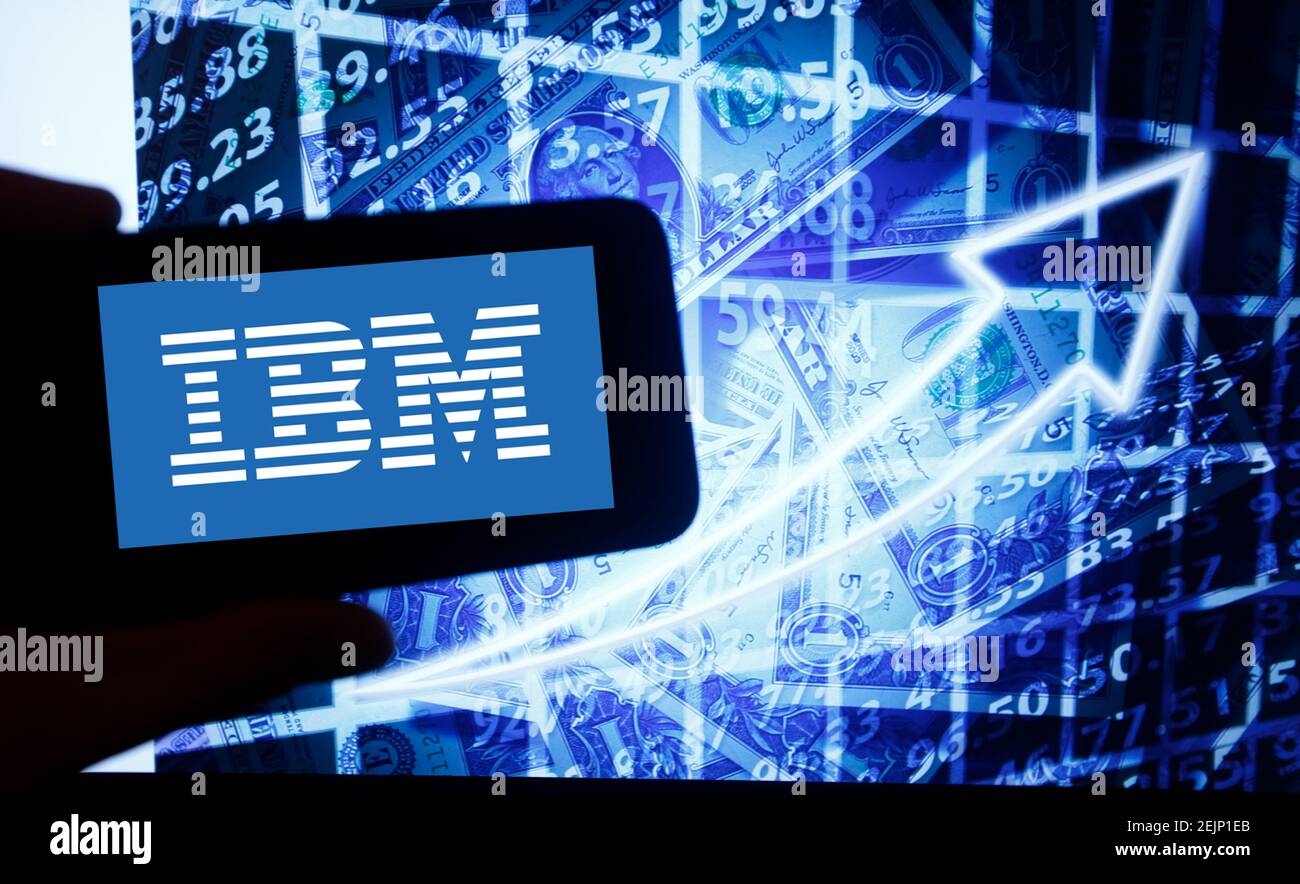 The logo of IBM is seen on a screen of a smartphone next to an ...
