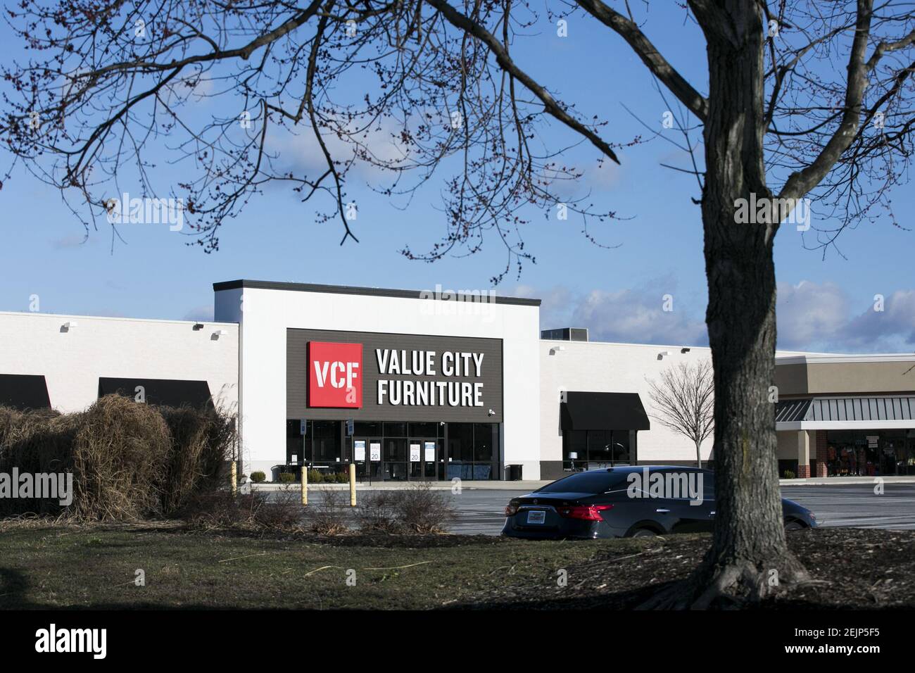 A logo sign outside of a Value City Furniture (VCF) retail store ...
