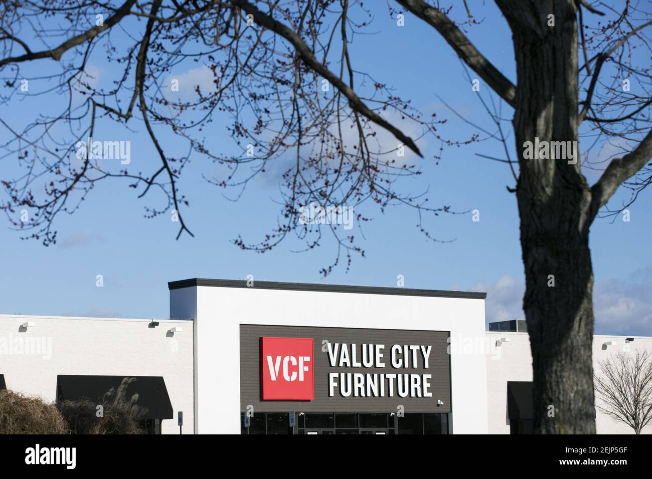 A logo sign outside of a Value City Furniture (VCF) retail store ...