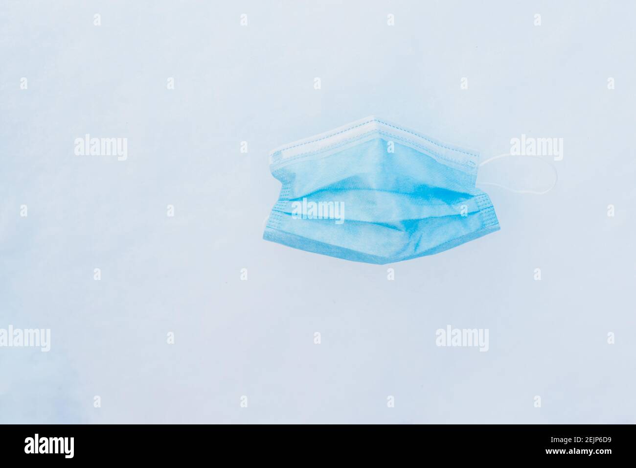 Medical mask in the snow Stock Photo - Alamy