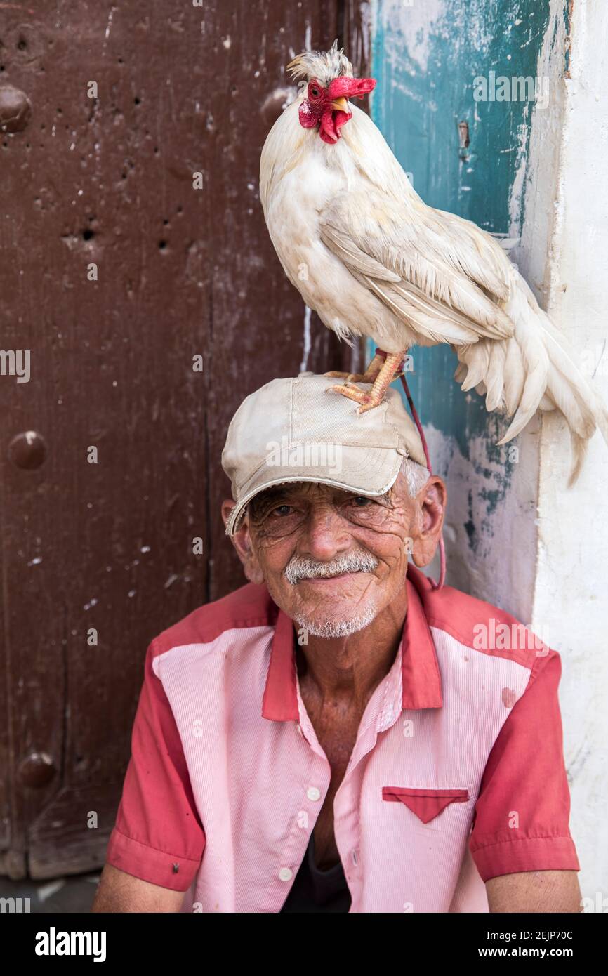 Portrait of an old Cuban man with a pet chicken on his head Stock Photo ...